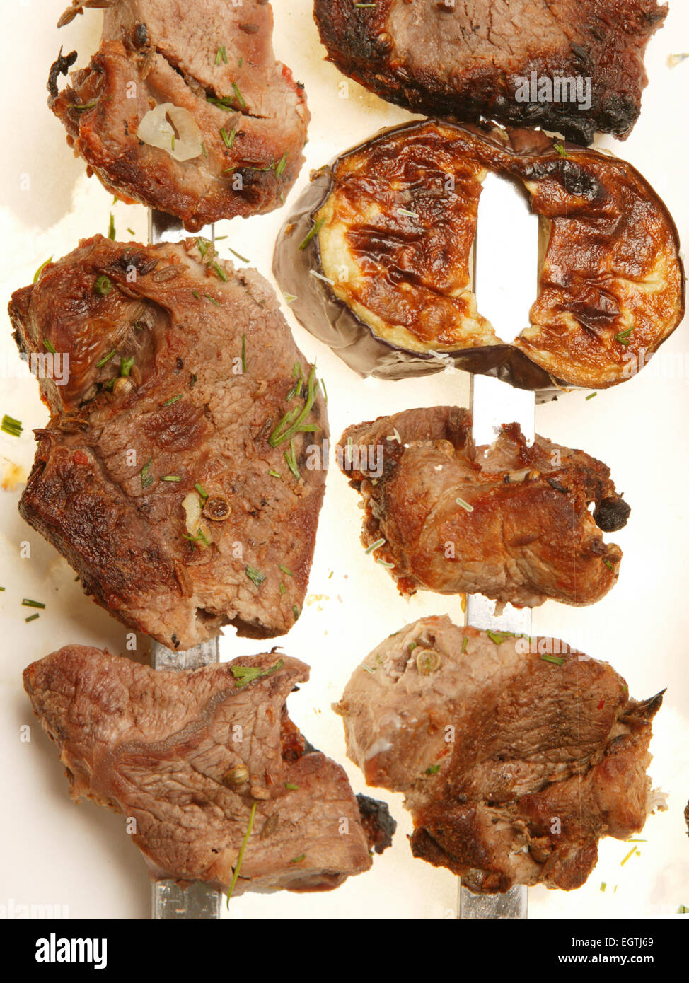 Grilled meat on spit against white background Stock Photo - Alamy