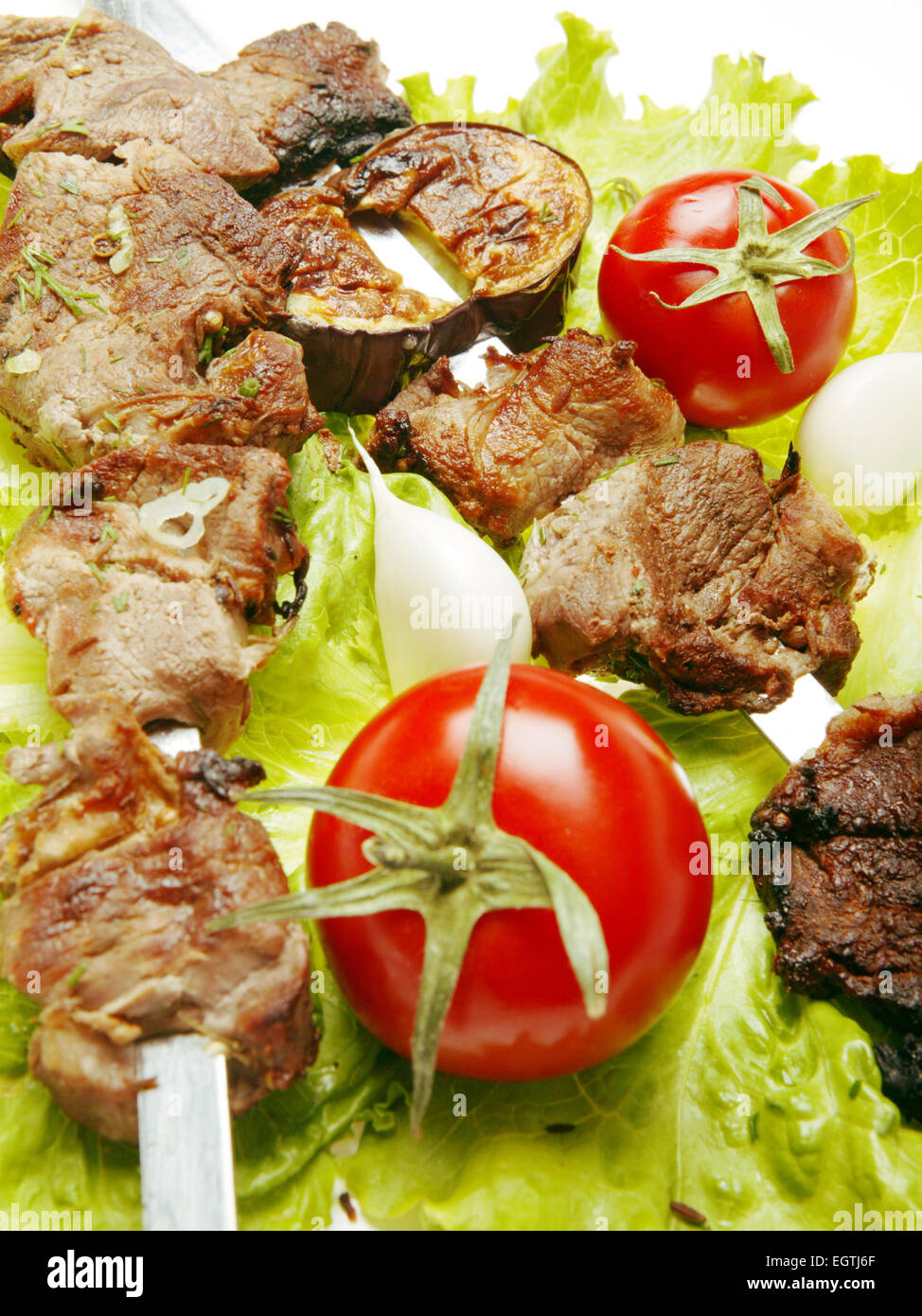 Grilled meat and vegetables on spit with herbs and vegetables Stock ...