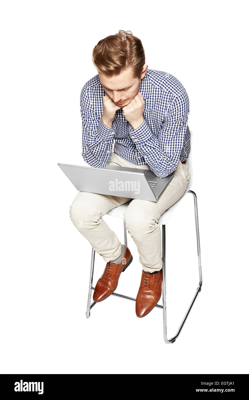 Young man thinking over the computer. He is sad Stock Photo - Alamy