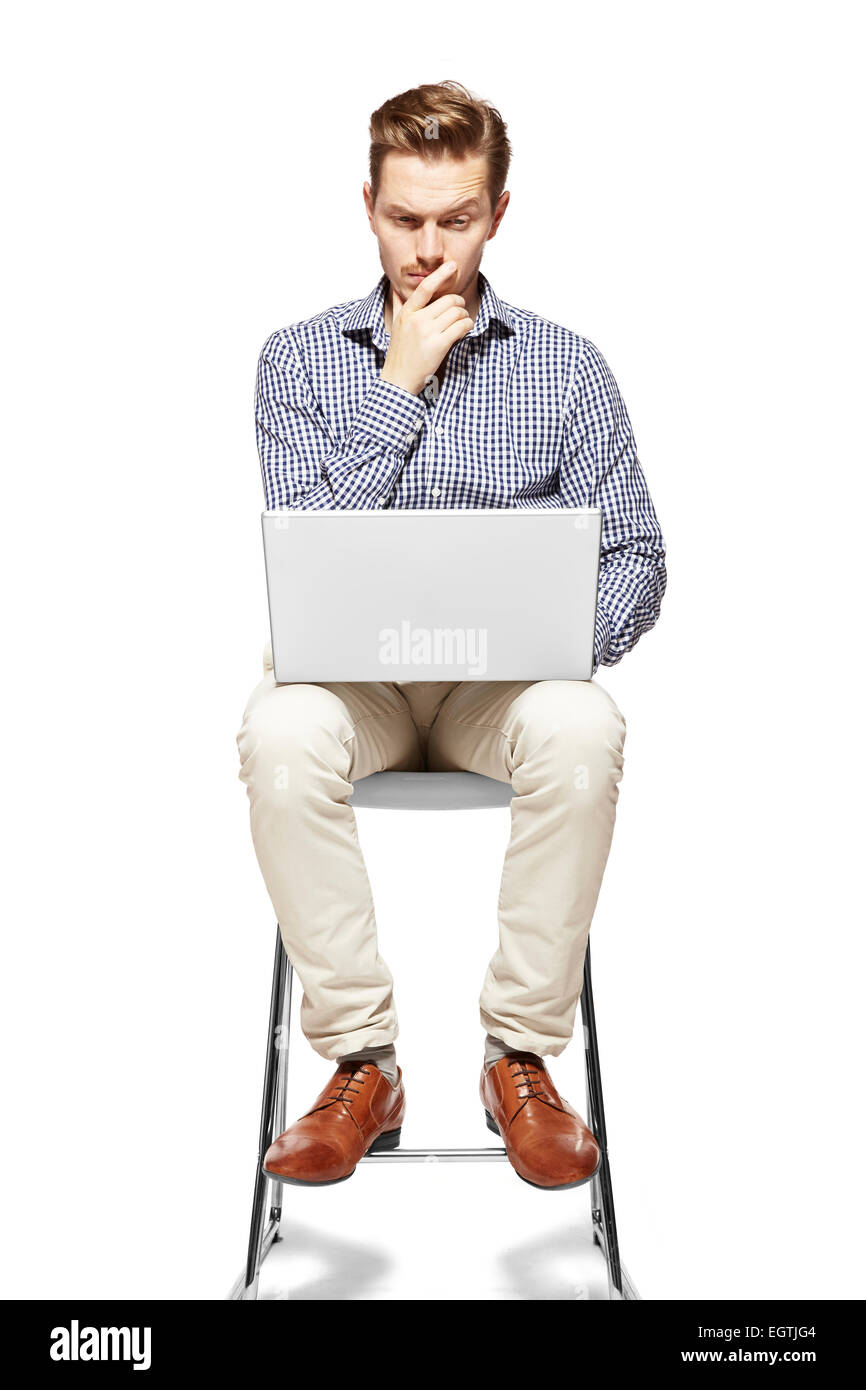 Young man working on a computer and thinking Stock Photo - Alamy