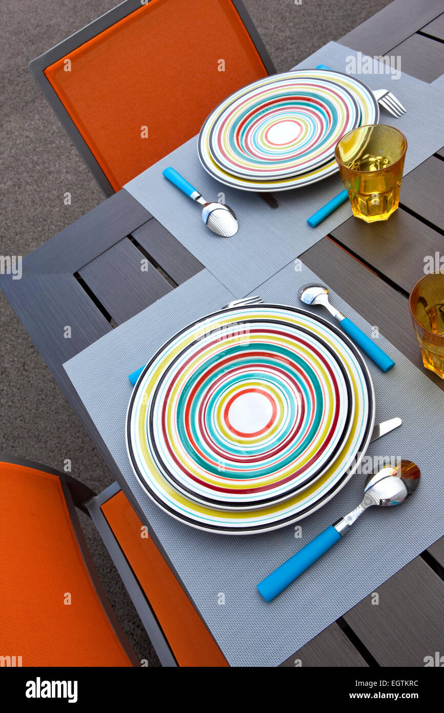 Plats, glasses and cutlery on a wooden table Stock Photo - Alamy