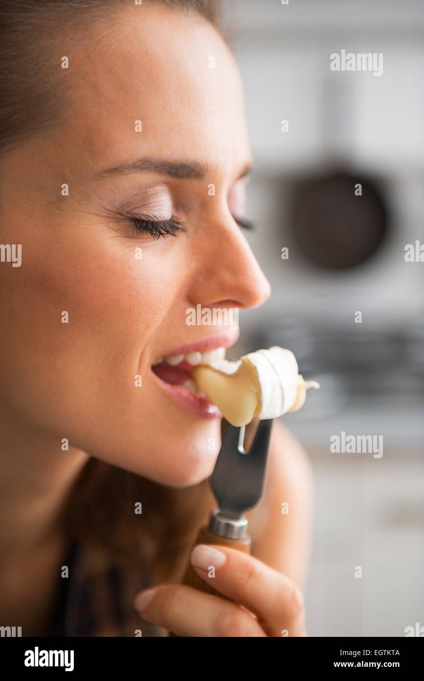 Young woman eating camembert Stock Photo - Alamy