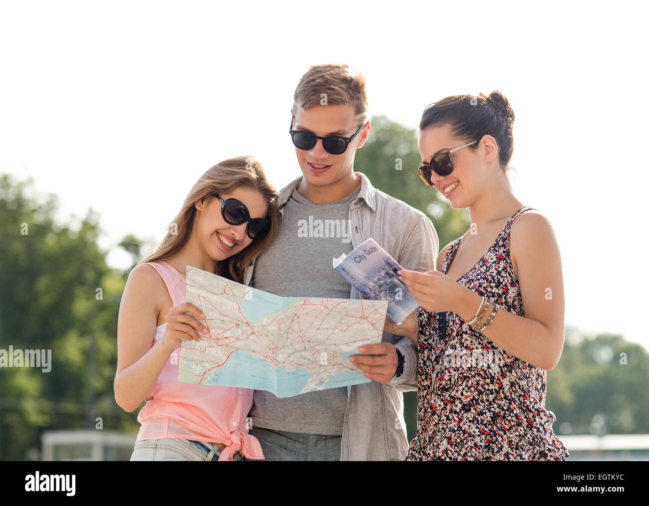 smiling friends with map and city guide outdoors Stock Photo - Alamy