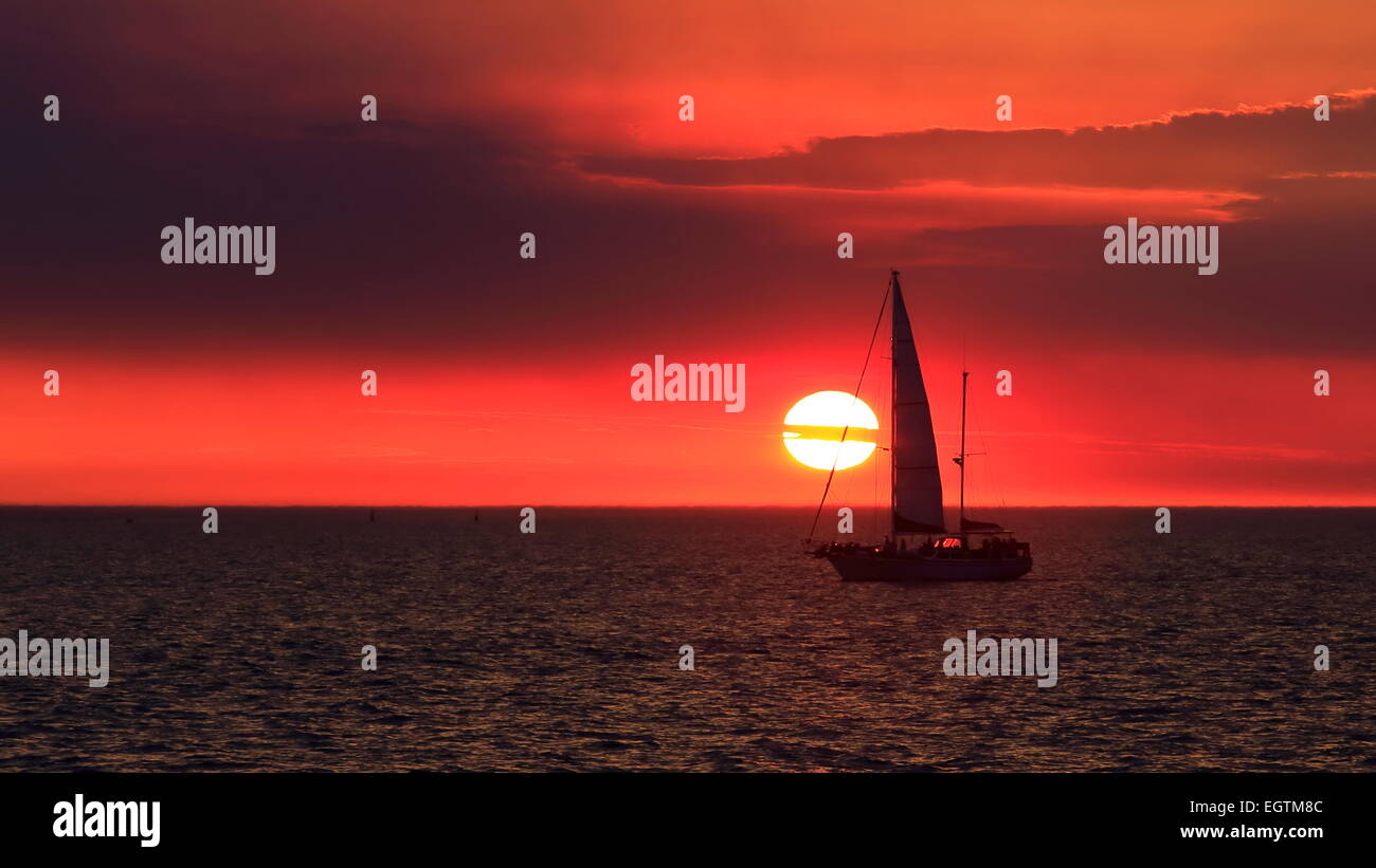 A Sail with Sun setting in the background Stock Photo - Alamy