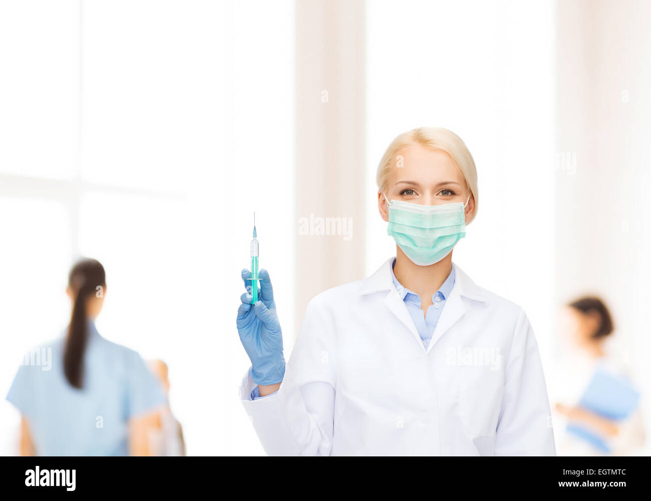 doctor in mask holding syringe with injection Stock Photo - Alamy