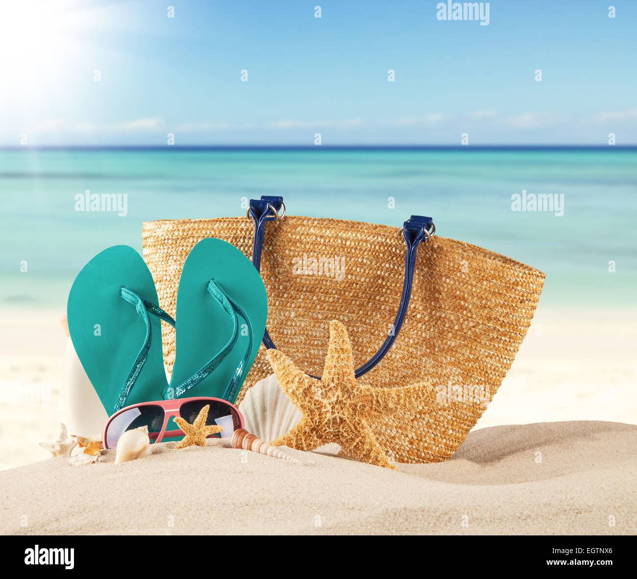Summer concept with sandy beach, shells and blue sandals Stock Photo ...