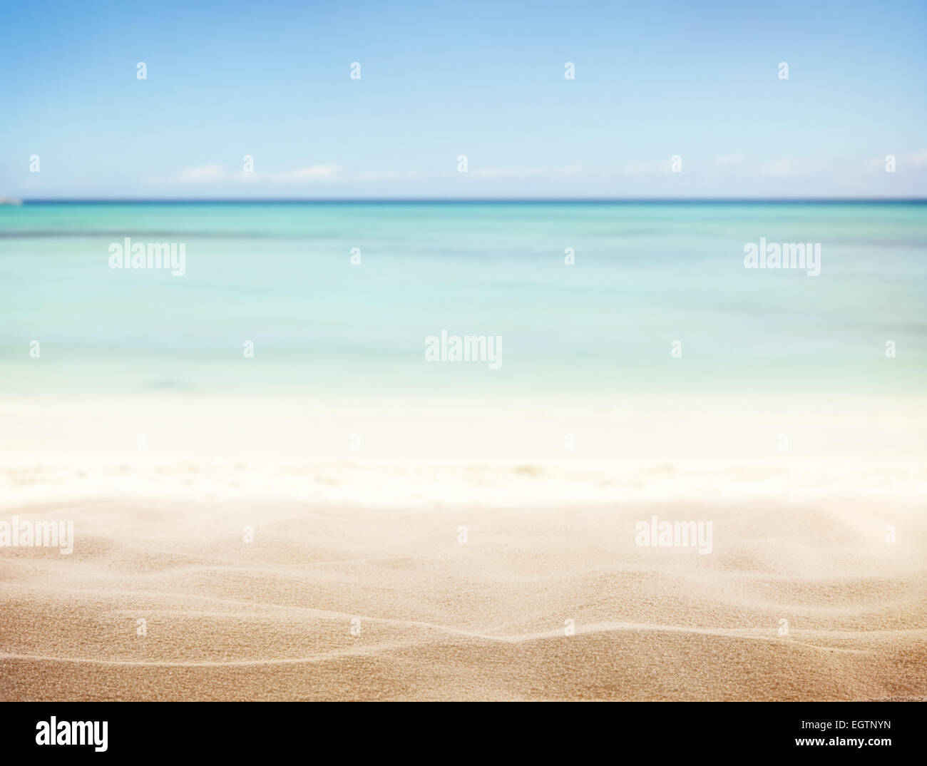Sandy beach with blur sea on background Stock Photo - Alamy