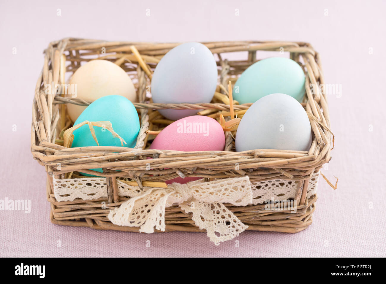 Easter eggs in pastel colours in a small basket Stock Photo - Alamy