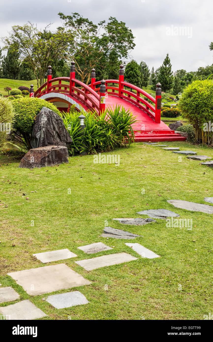 Small red bridge in a Japanese garden Stock Photo - Alamy