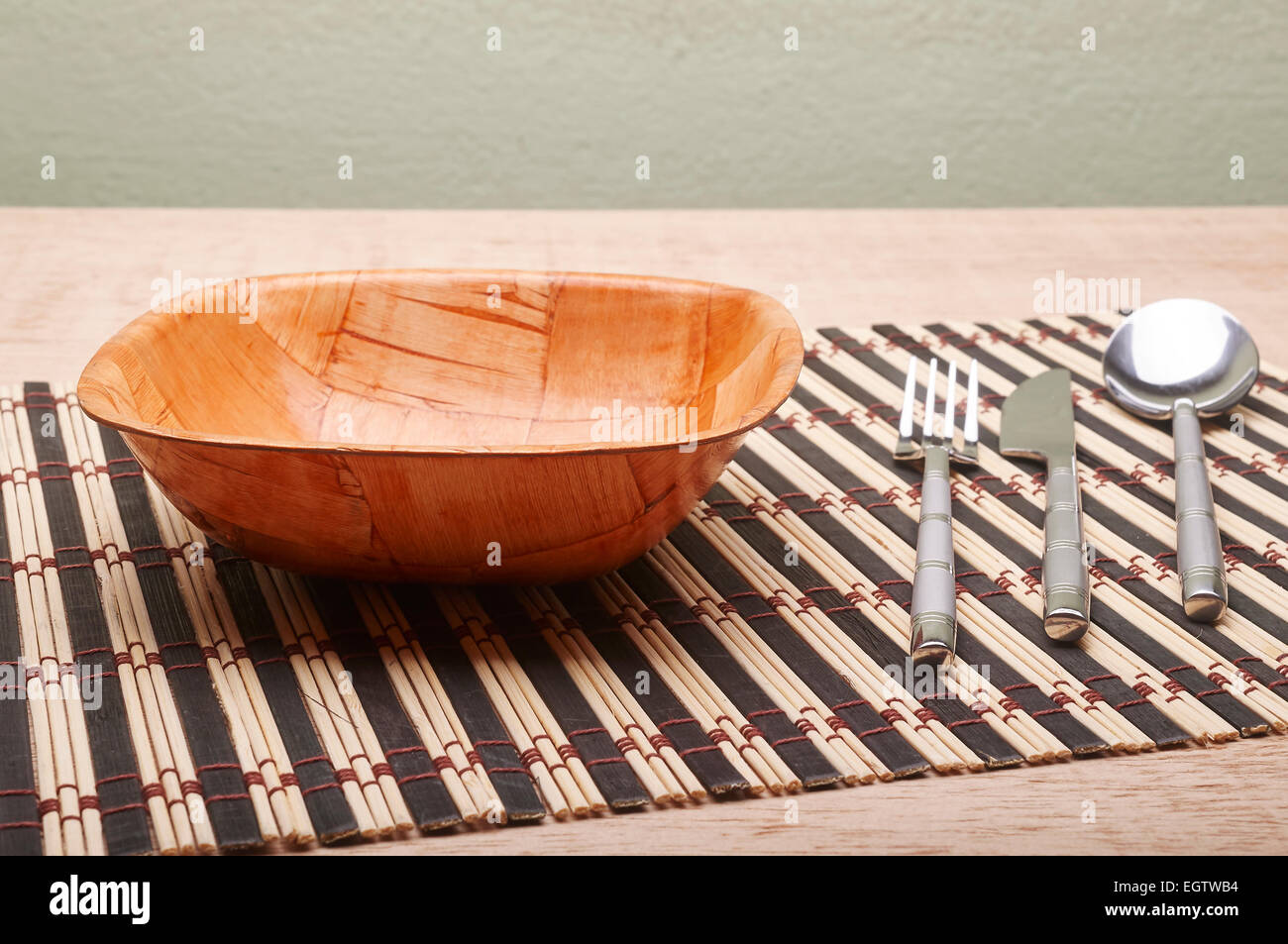 Bowl, fork, knife and spoon on placemats on dining table Stock Photo ...