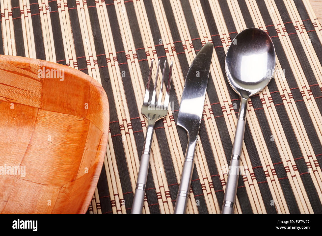 Bowl, fork, knife and spoon on placemats on dining table Stock Photo ...