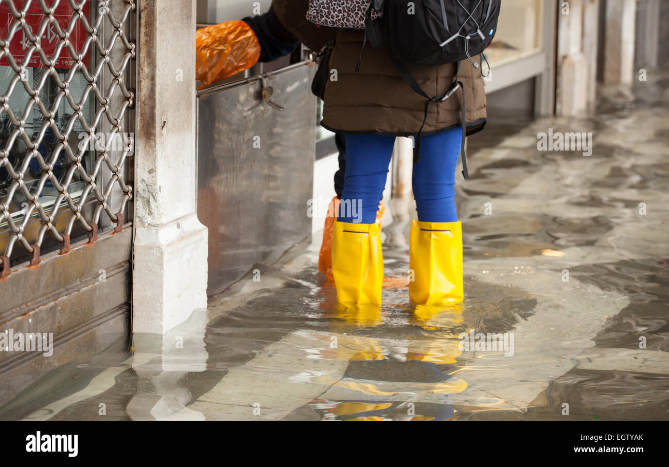 Close Up of legs with boots due to the high water. This flood happens ...