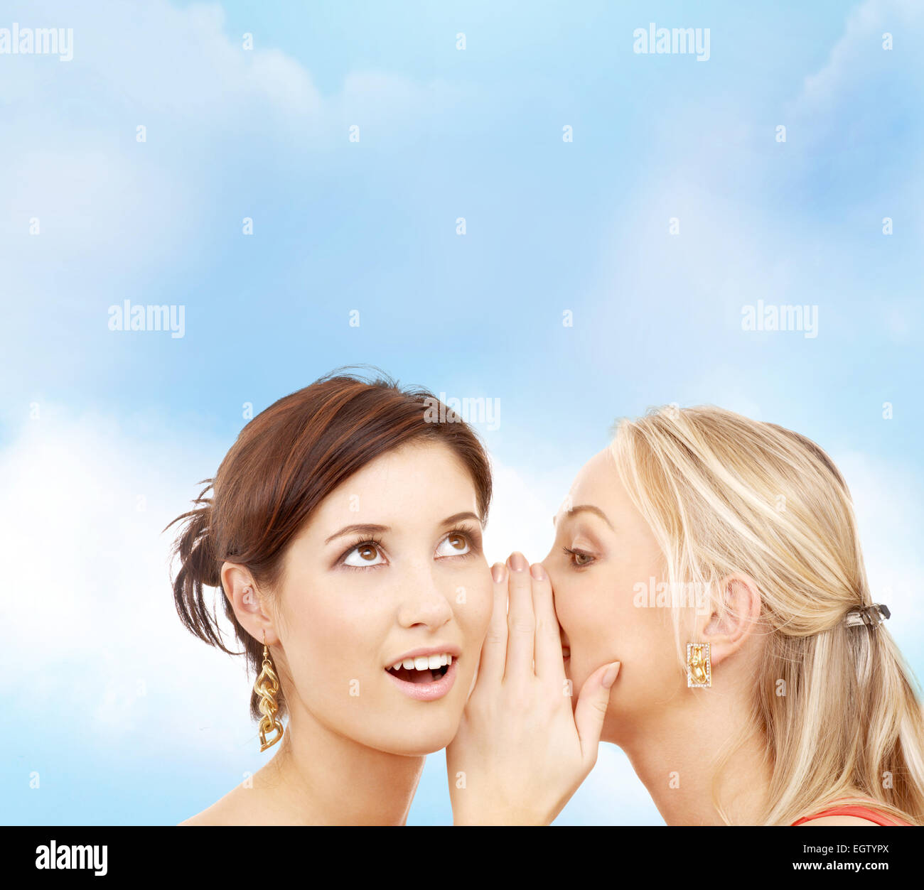 two smiling women whispering gossip Stock Photo - Alamy