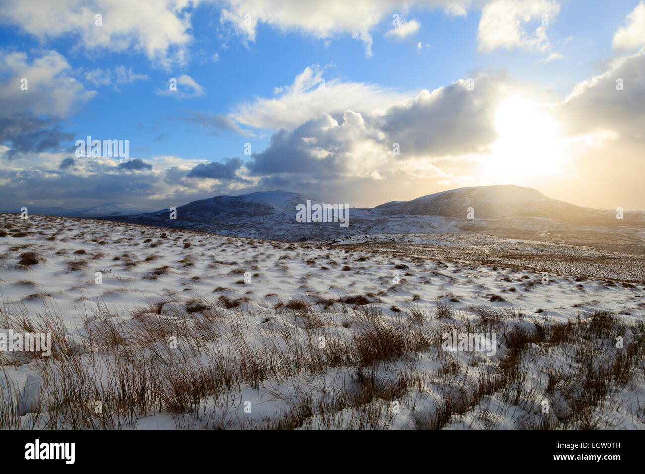 A low Winter Sun begins to set over Arenig Fach, Snowdonia. Arenig Fawr ...