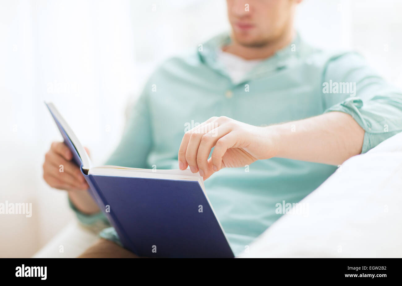 close up of man reading book at home Stock Photo - Alamy