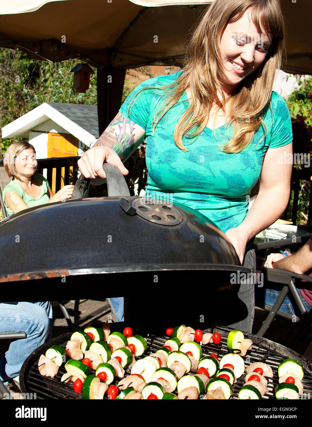 Woman lifting lid on grill Stock Photo - Alamy