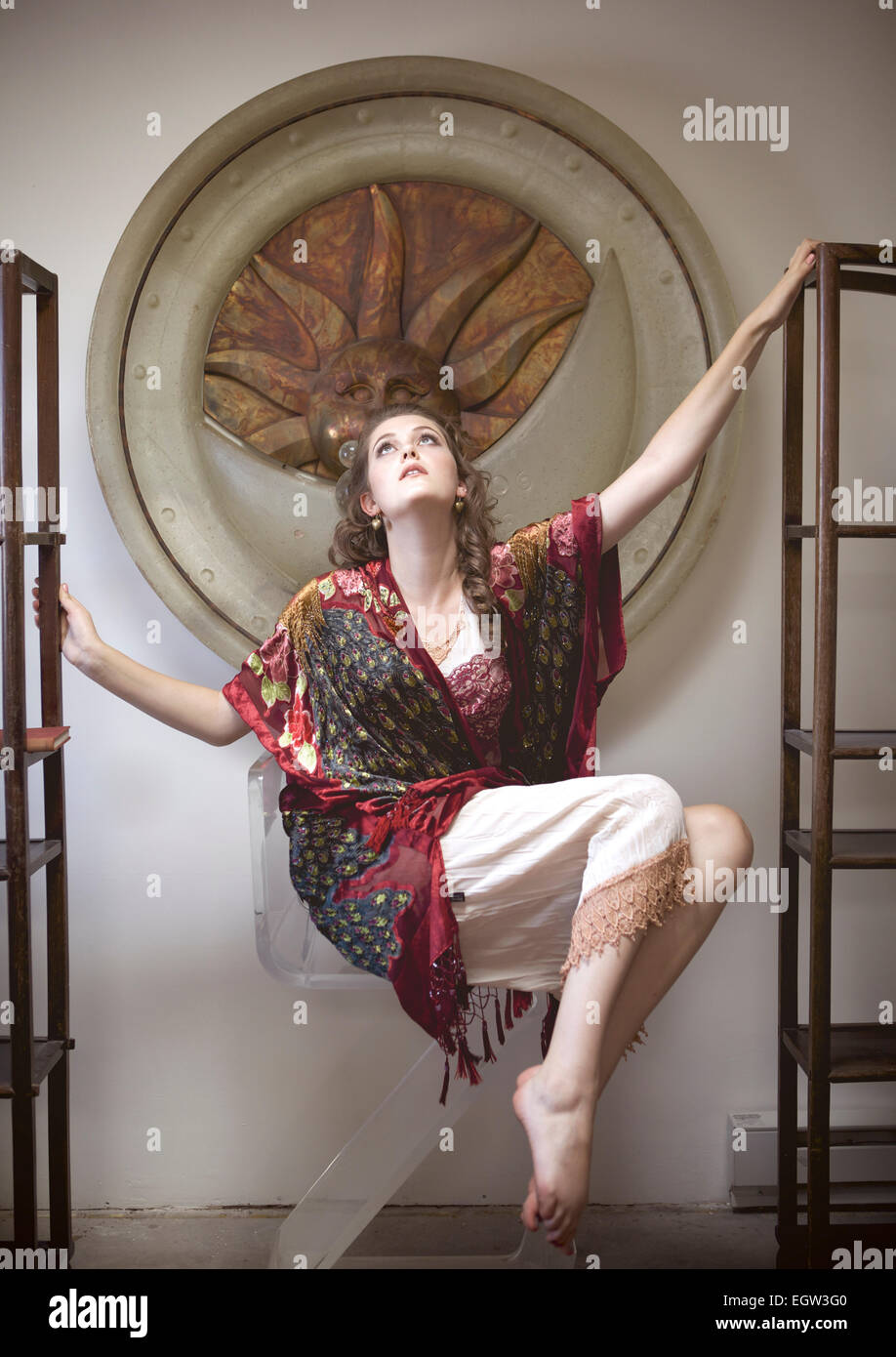 Woman on chair with feet lifted Stock Photo - Alamy