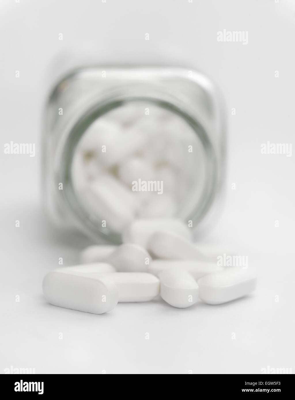 White tablets in a small glass jar close up Stock Photo - Alamy