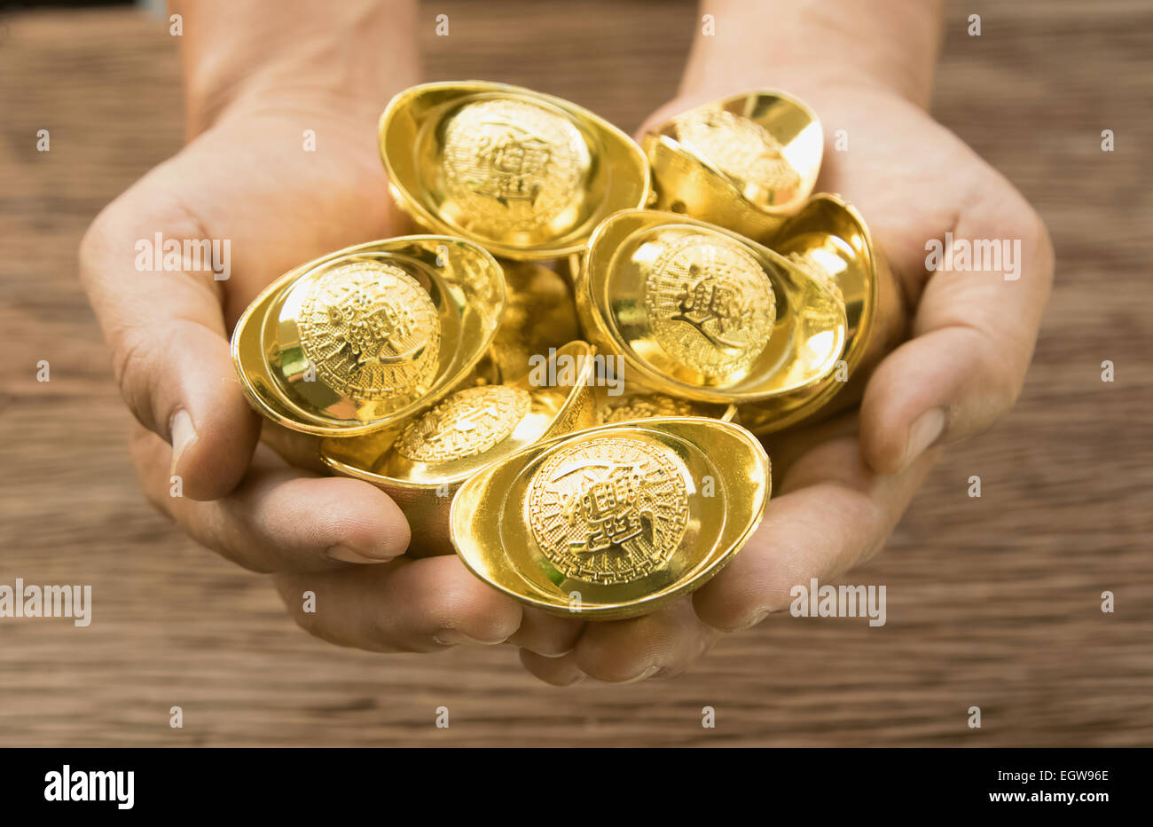 Hand hold chinese gold ingots Stock Photo - Alamy