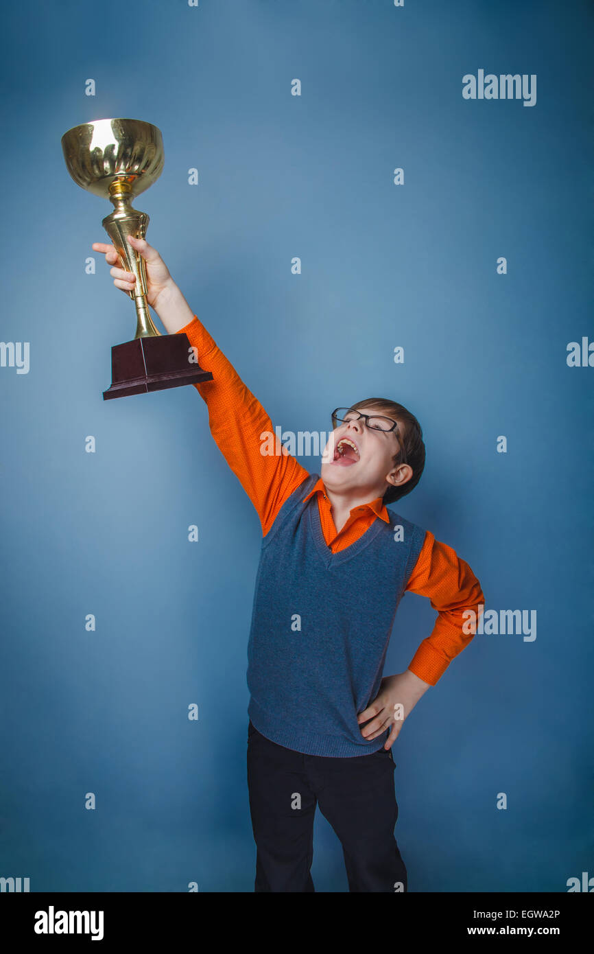 European-looking boy of ten years award cup joy on a gray bac Stock ...