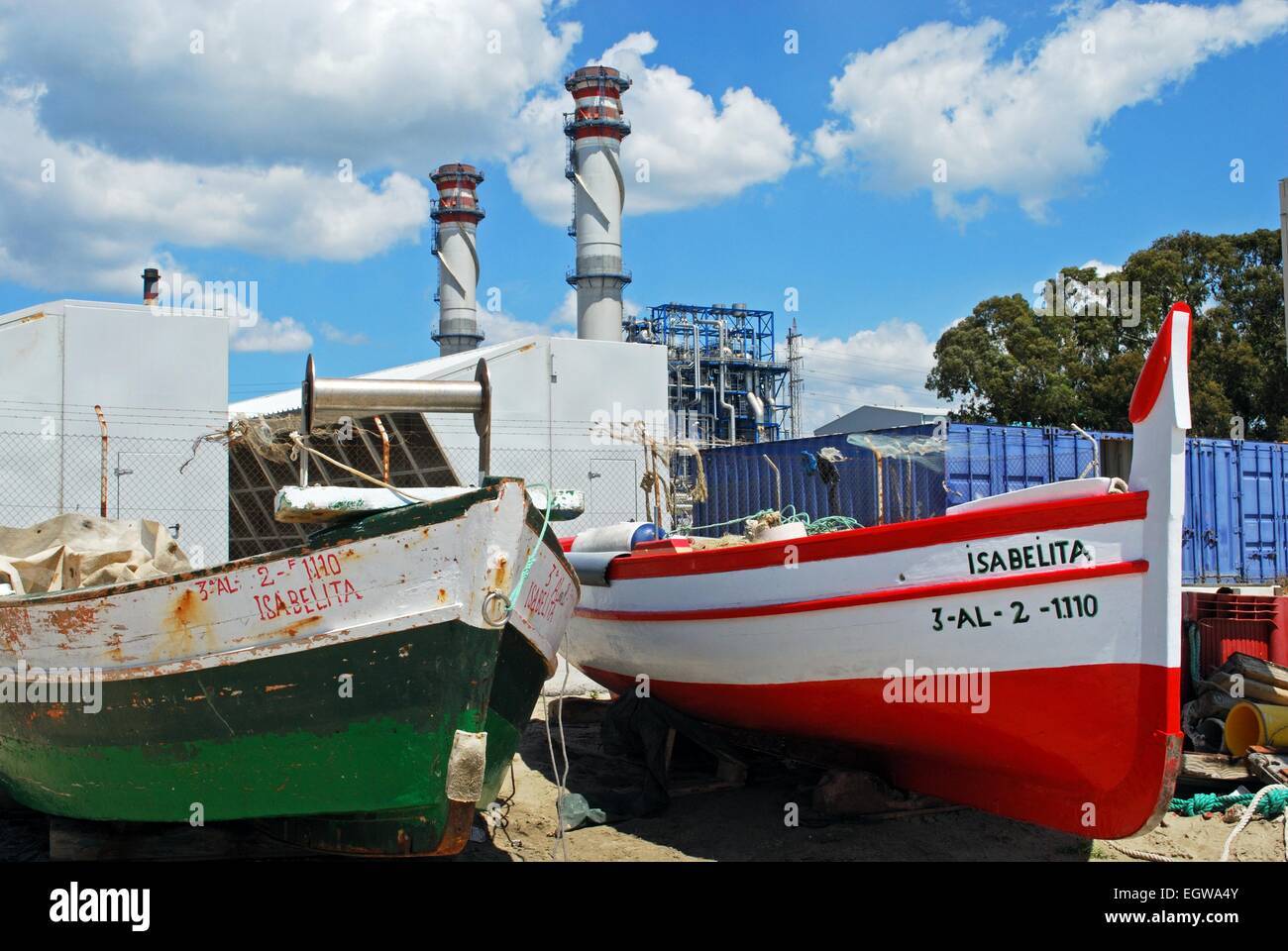 Traditional wooden fishing boats with petrochemical oil refinery to the ...