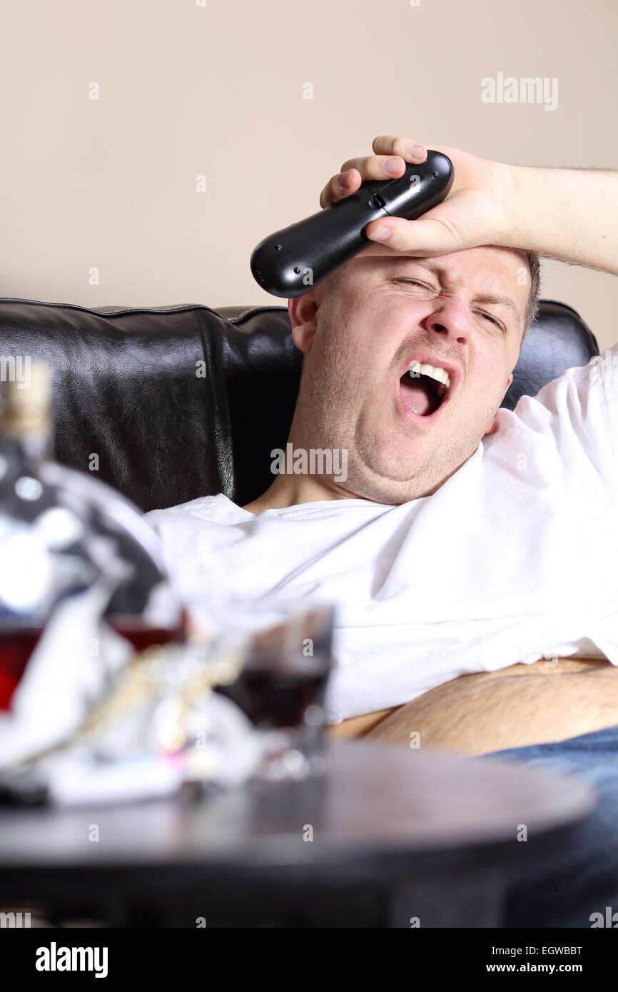 Yawning man on the couch watching TV Stock Photo - Alamy