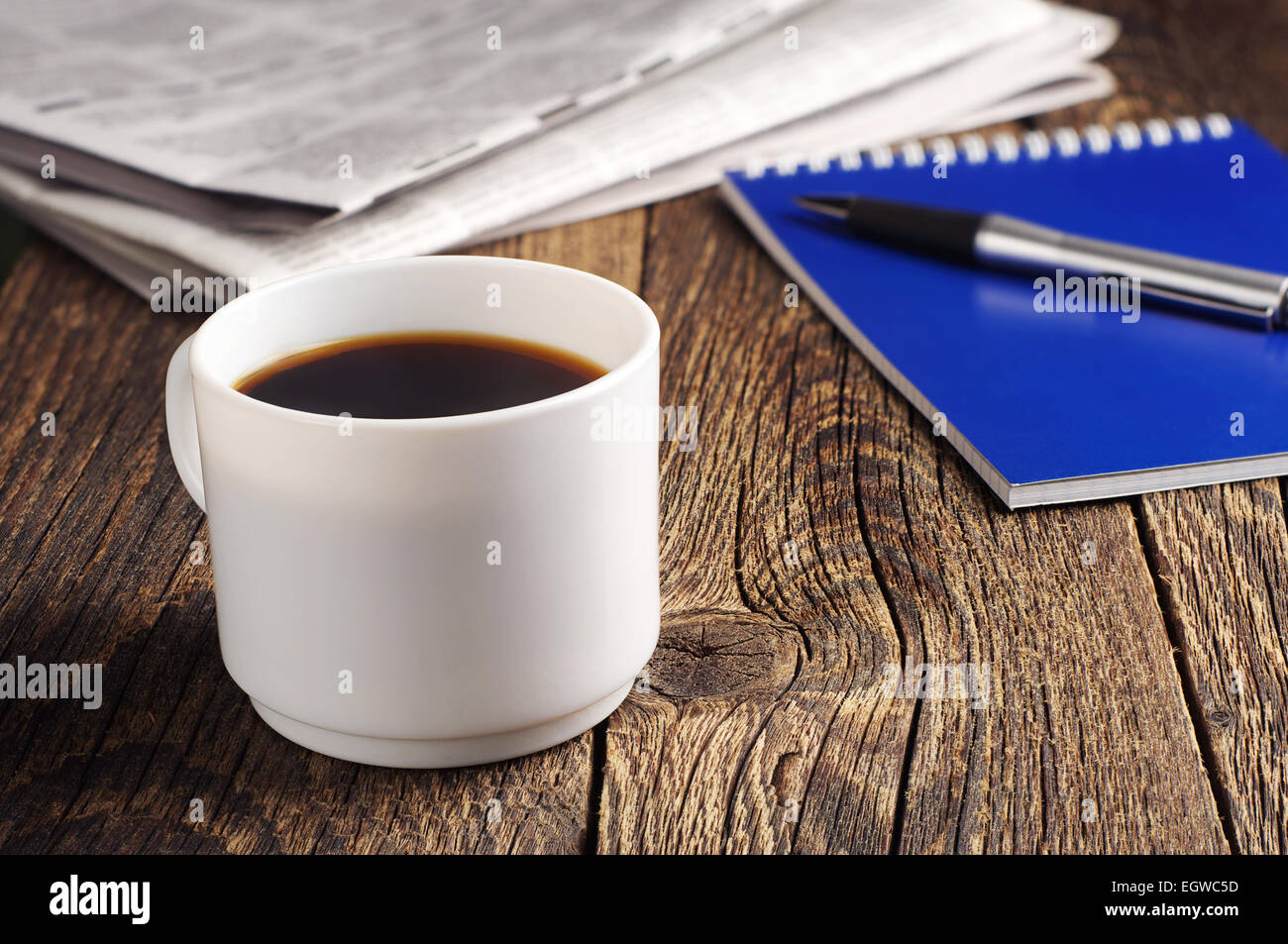 Cup of coffee, newspaper and notepad on old wooden table Stock Photo ...