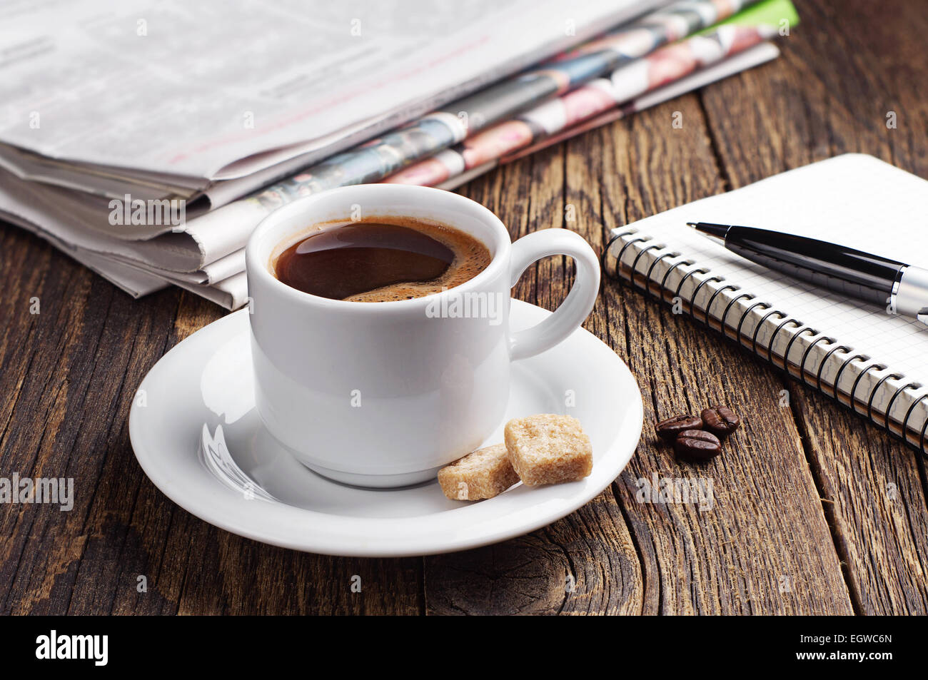 Cup of coffee, newspaper and notepad on old wooden table Stock Photo ...