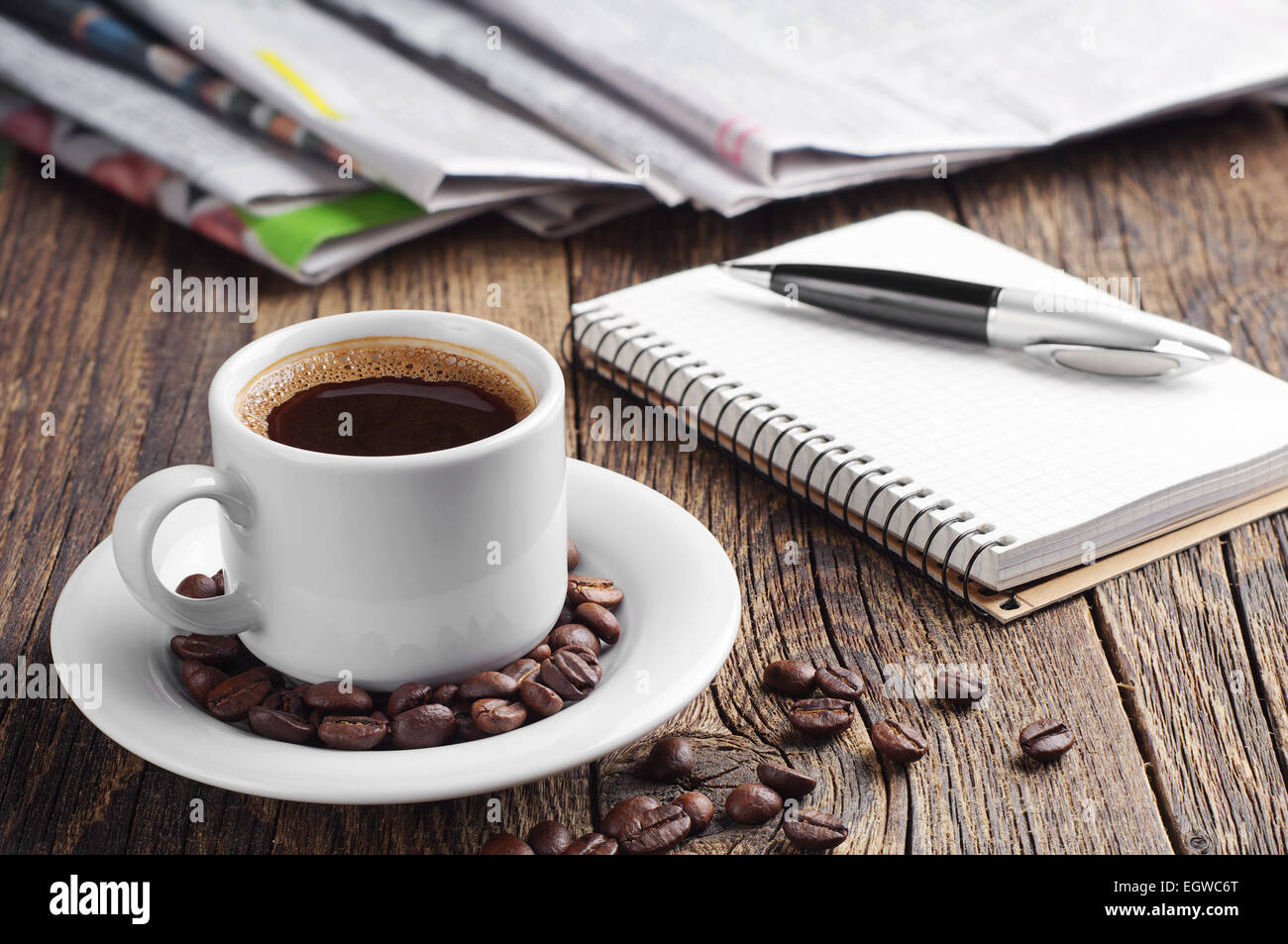 Cup of coffee, newspaper, notepad and pen on old wooden table Stock ...