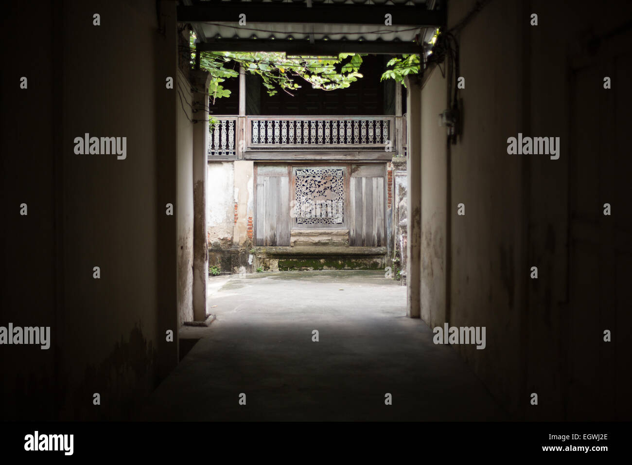 View through a dark alleyway into a brightly-lit courtyard with a ...