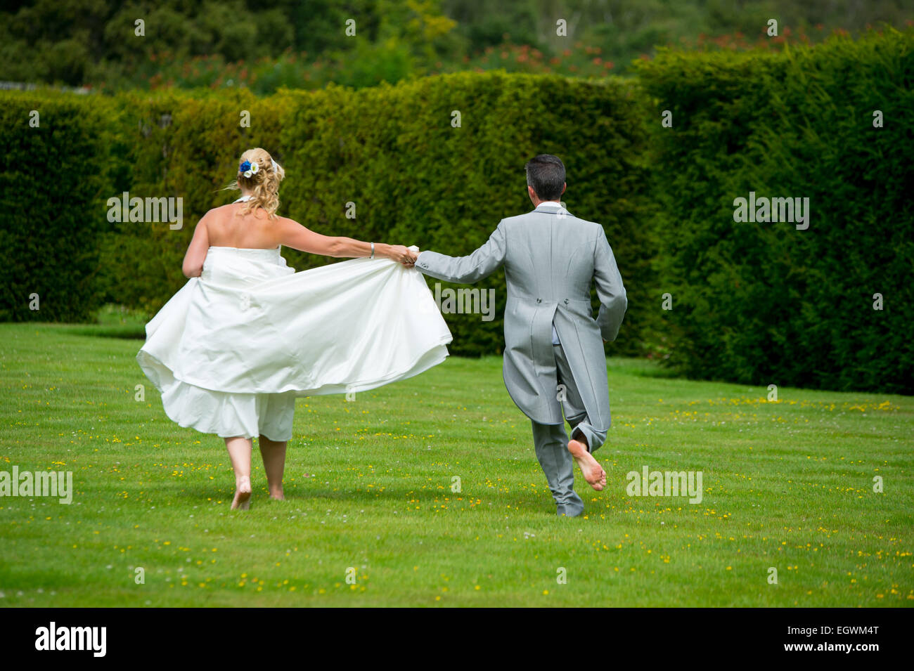 A recently married couple run around jumping in excitement of just ...