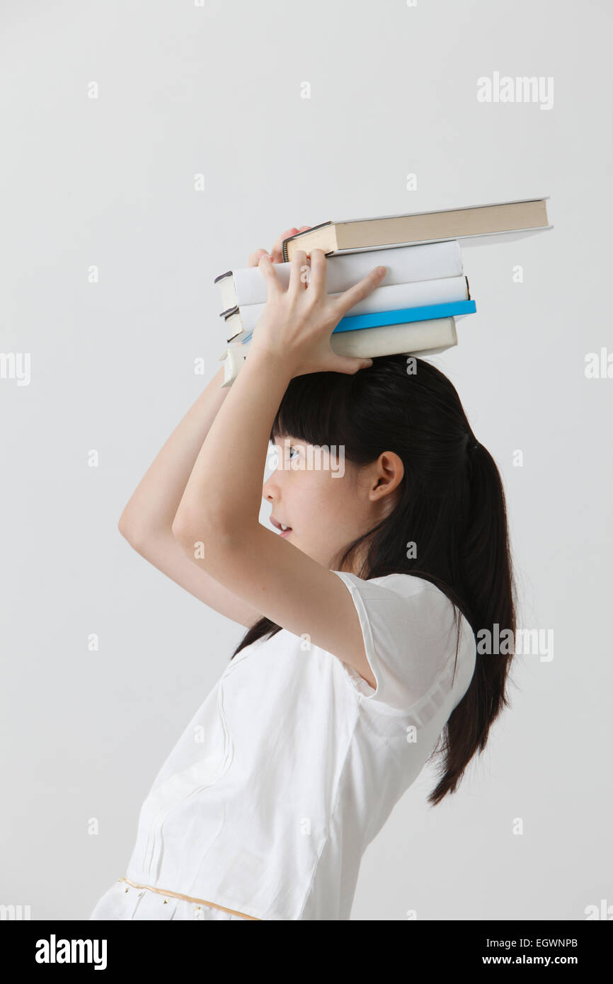 chinese girl balancing with books Stock Photo - Alamy