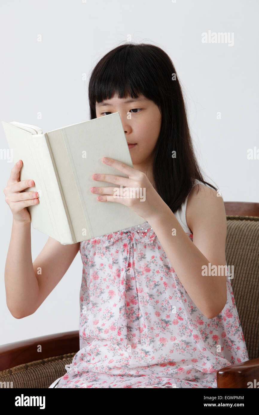 chinese girl sitting on the sofa reading book Stock Photo - Alamy