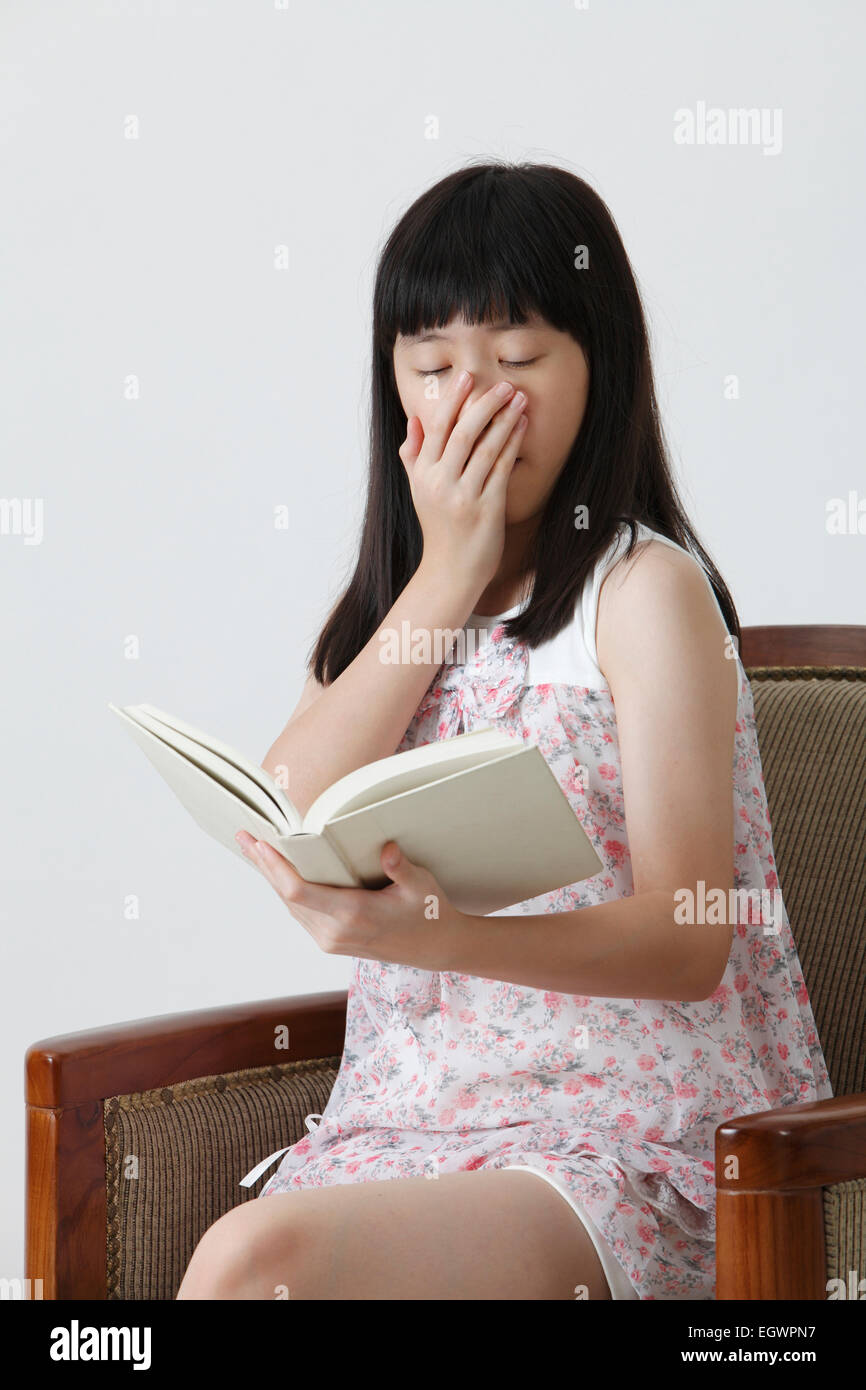 chinese girl reading boring story Stock Photo - Alamy