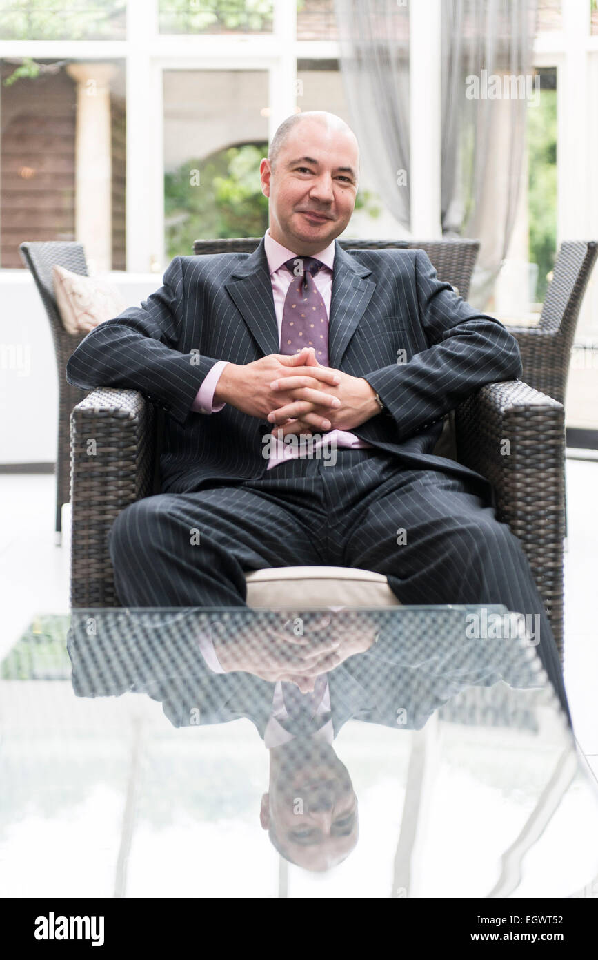 a relaxed professional businessman office manager sits in an armchair ...