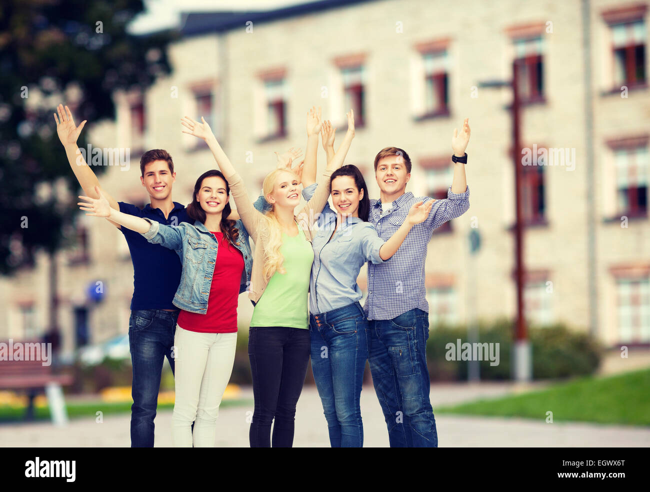 group of smiling students waving hands Stock Photo - Alamy