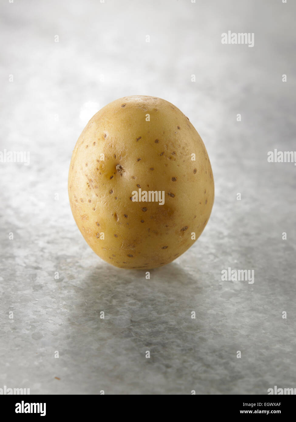 Single potato on the marble table Stock Photo - Alamy