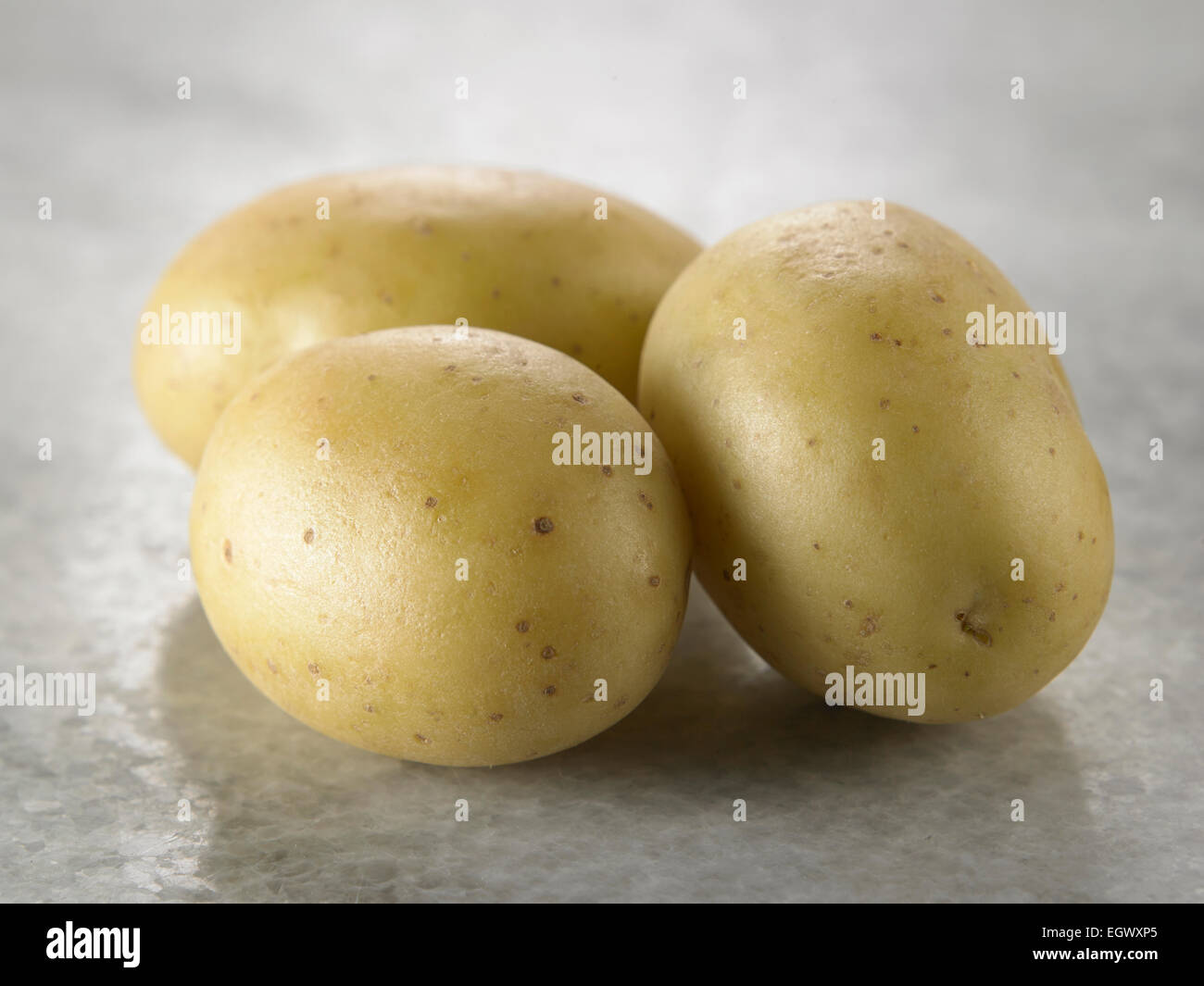 three potatoes on the marble top Stock Photo - Alamy