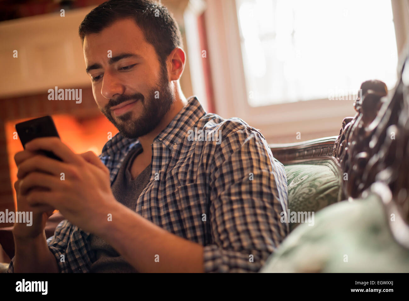 A man checking his cell phone and smiling Stock Photo - Alamy