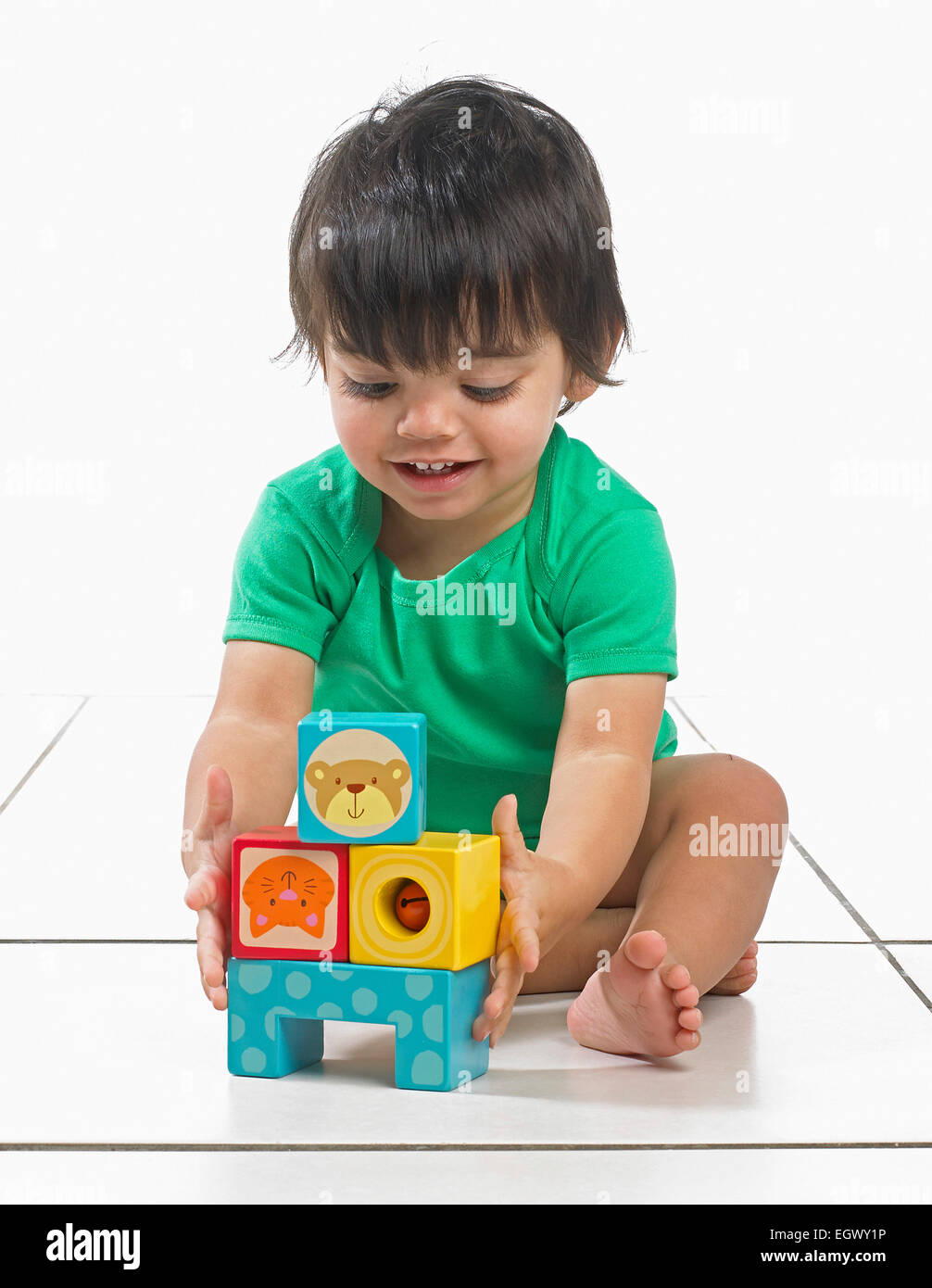 Baby boy (16 months) sitting playing with building blocks Stock Photo ...