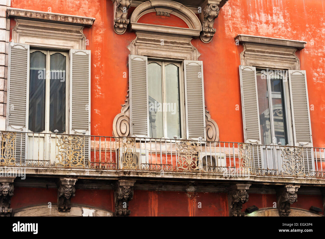 A traditional exterior of an Italian building with doors with shutters ...