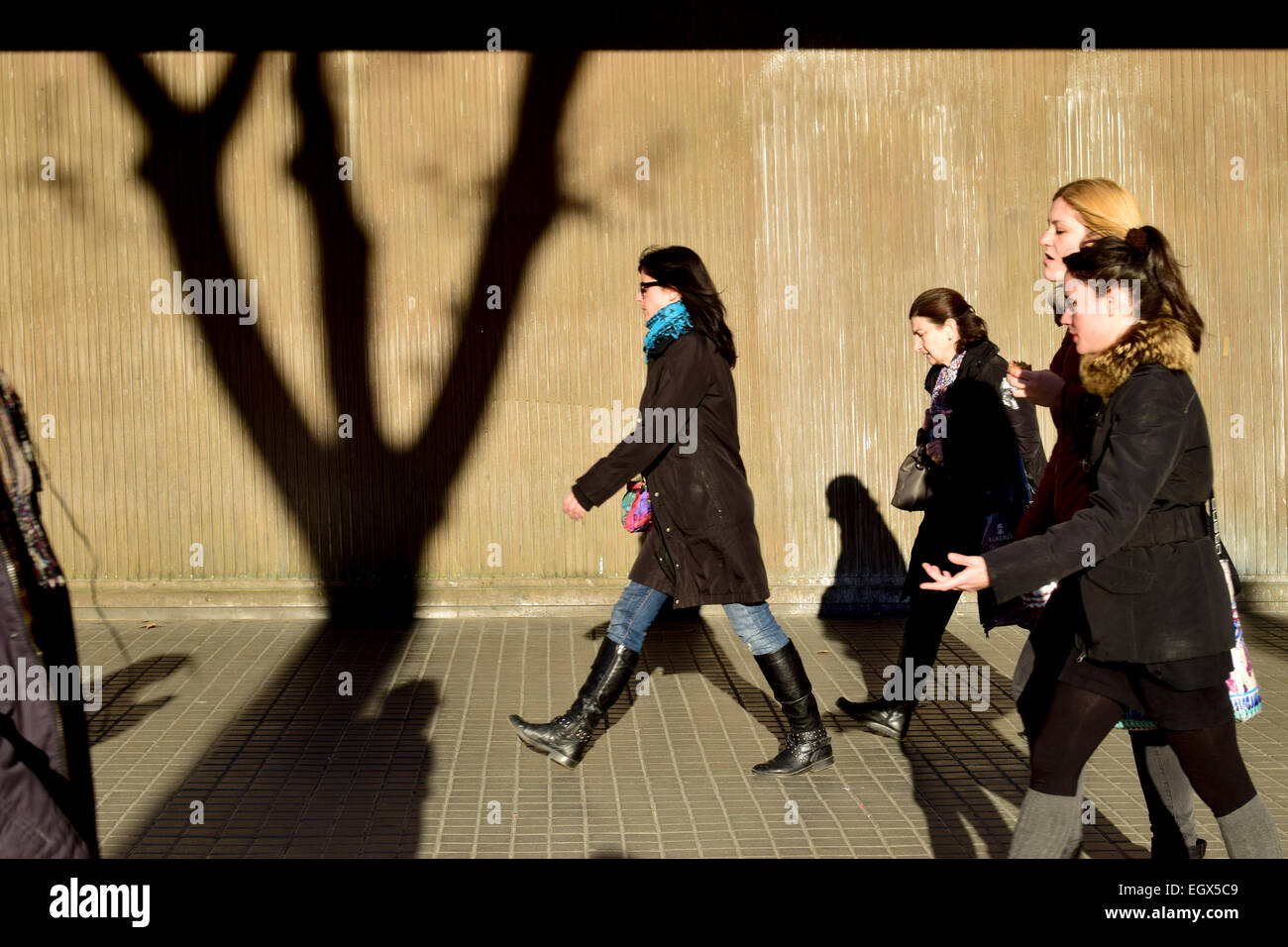 People walking along a wall Stock Photo - Alamy
