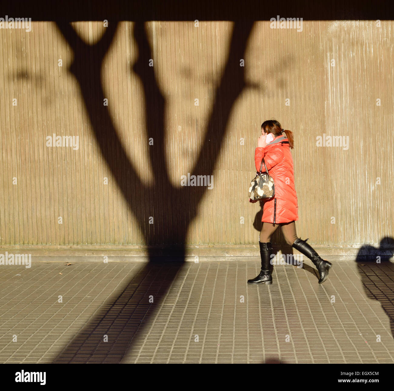 People walking along a wall Stock Photo - Alamy