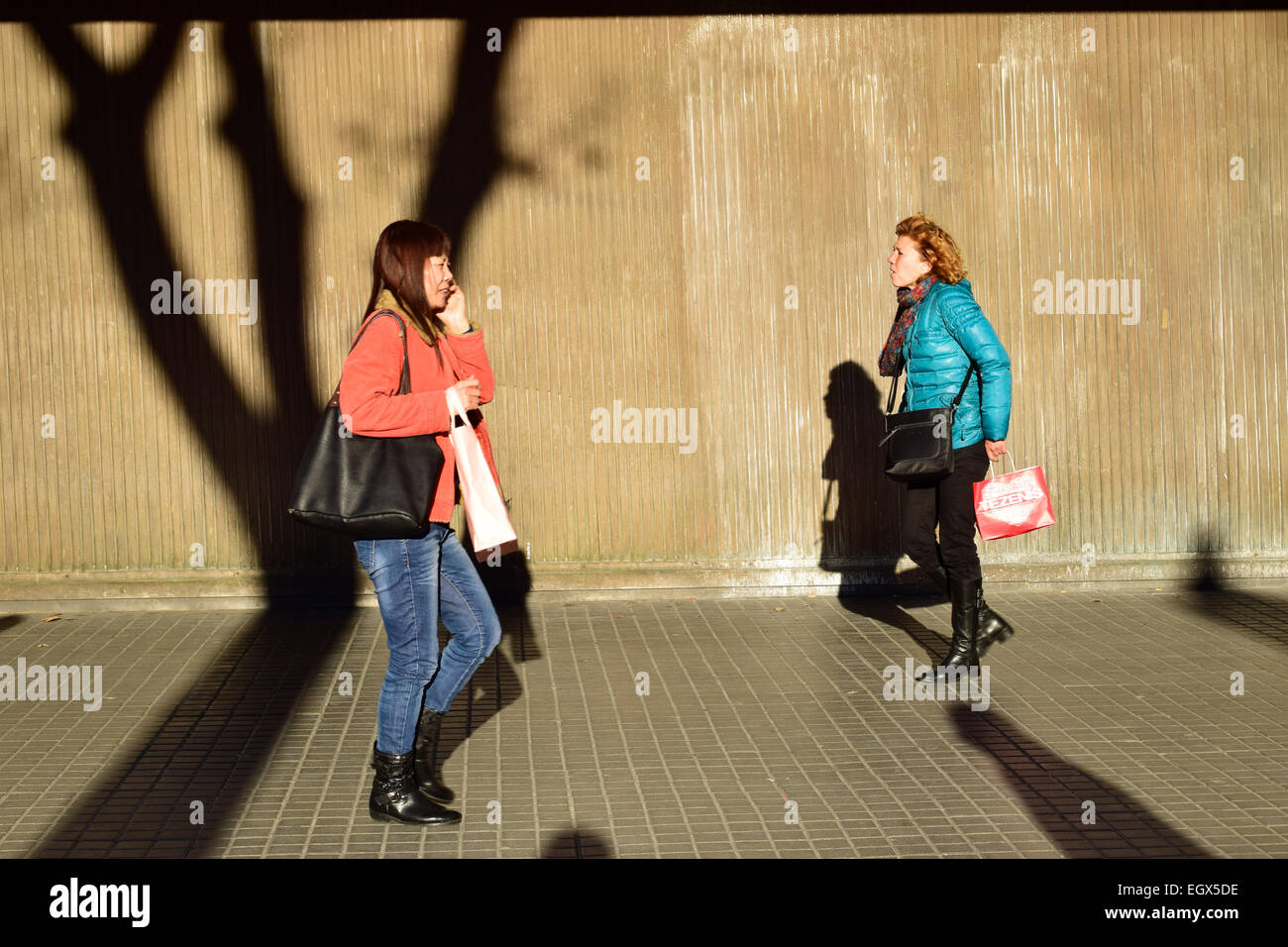 People walking along a wall Stock Photo - Alamy
