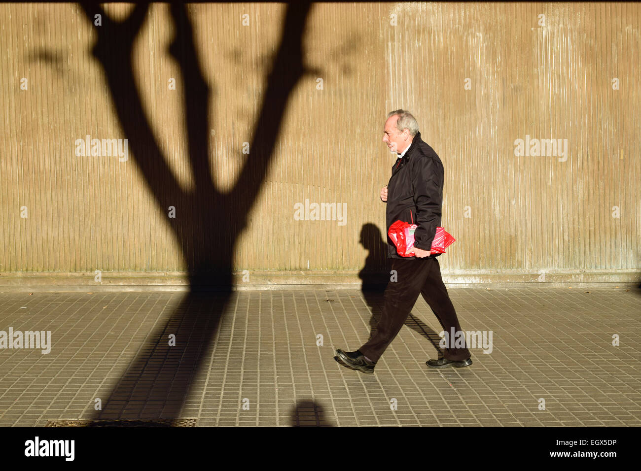 People walking along a wall Stock Photo - Alamy