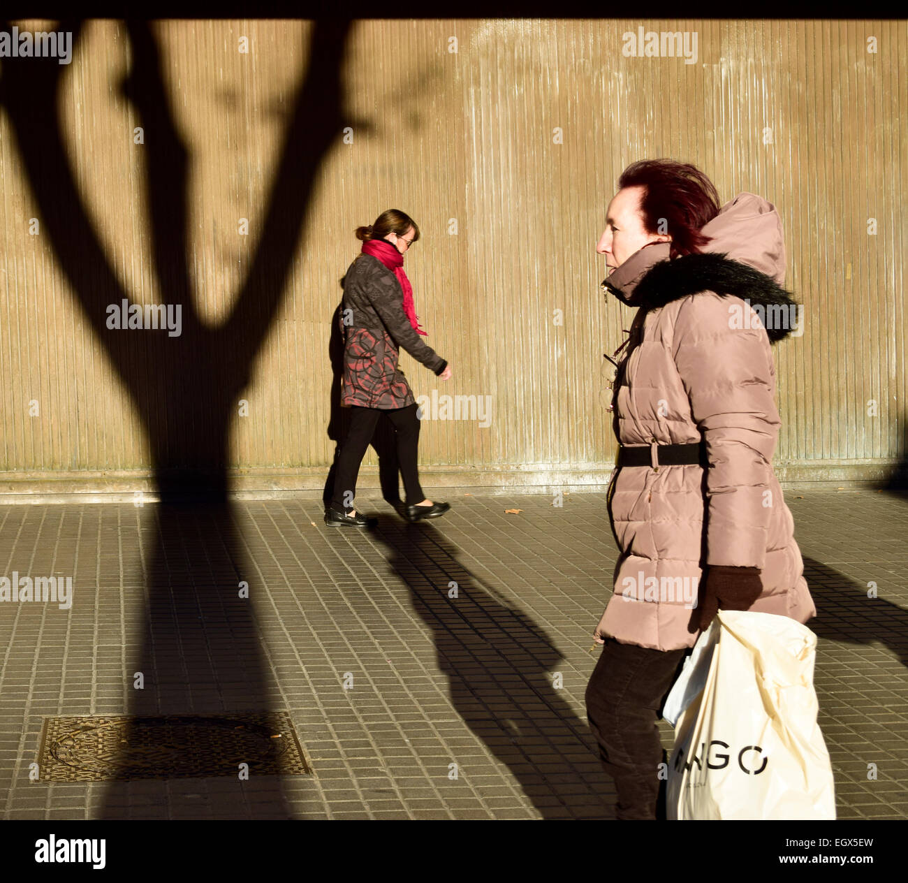 People walking along a wall Stock Photo - Alamy