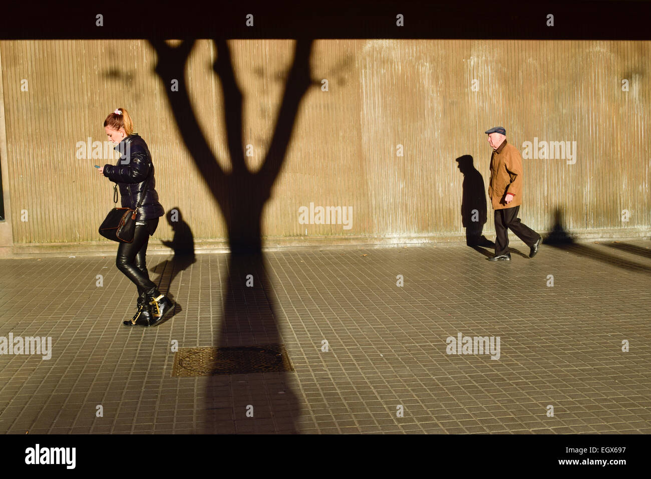 People walking along a wall Stock Photo - Alamy
