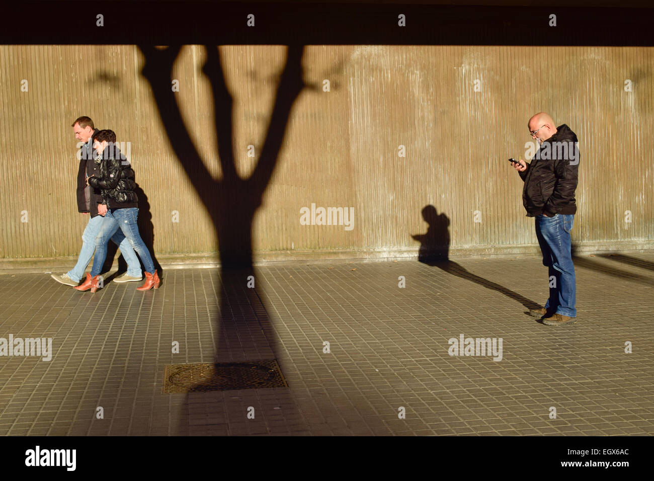People walking along a wall Stock Photo - Alamy