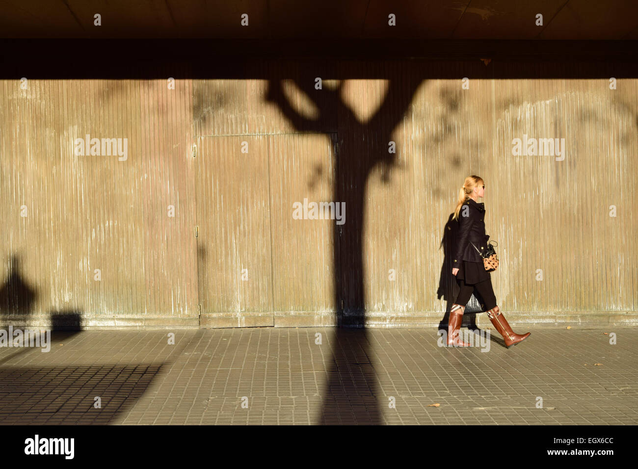 People walking along a wall Stock Photo - Alamy
