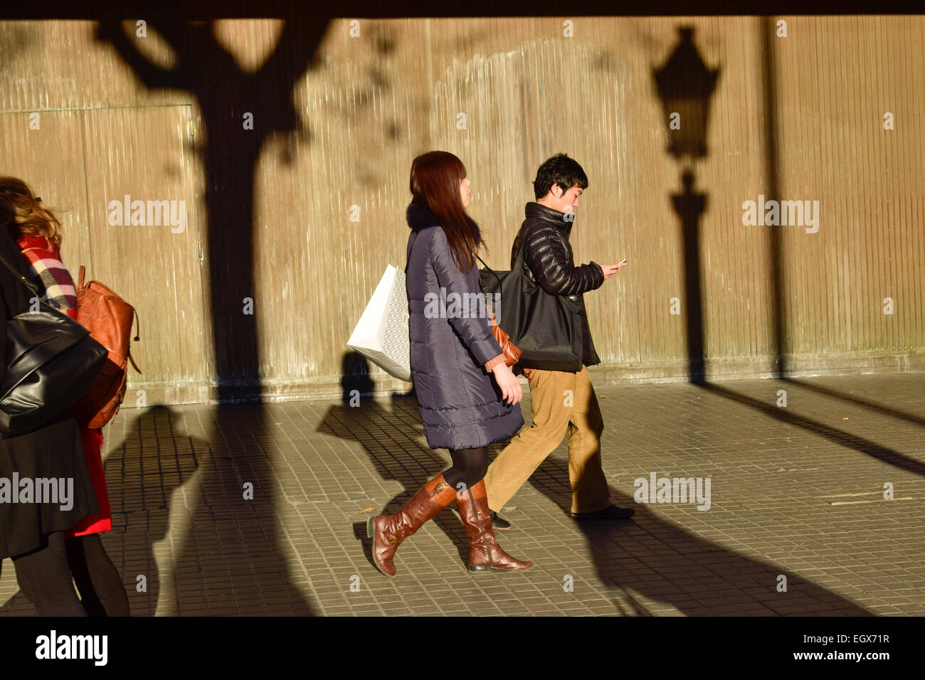 People walking along a wall Stock Photo - Alamy